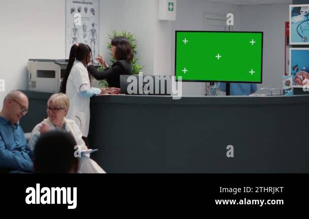 Monitor display with greenscreen background in hospital reception desk ...