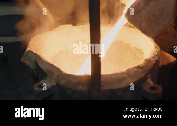Molten metal is poured into the melting pot. Close-up. Metallurgy ...