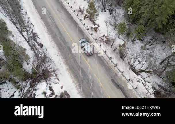 Aerial view of mountain twisted road in the winter and driving car ...