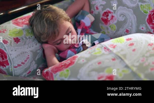 Toddler boy sleeping on sofa at night. Slouched tired child asleep ...