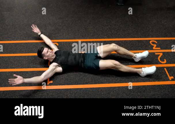 Gym abs workout exercise. Sportsman man in sportswear doing raised-leg ...