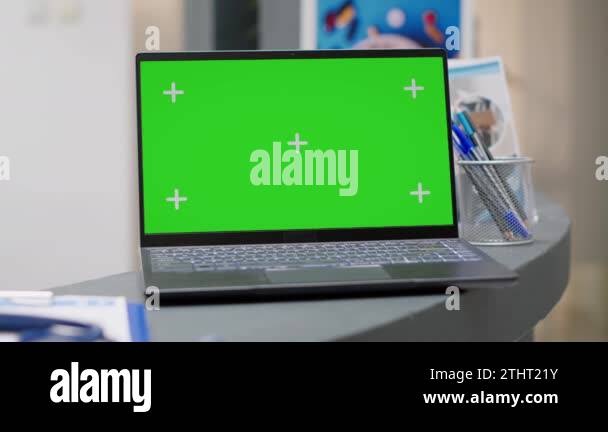 Greenscreen display on laptop at hospital reception desk, private ...
