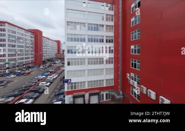 Motion inside modern office building with red facade from city street ...
