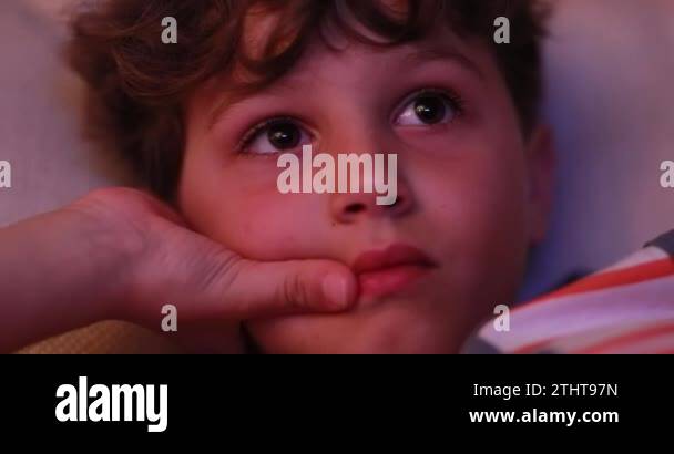 Young boy staring TV screen at night, real life candid child watching ...