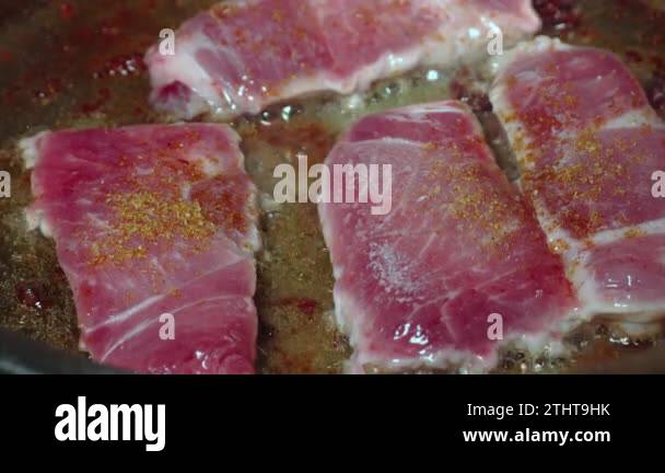 Searing beef bottom round roasted meat in cast iron skillet in boiling ...