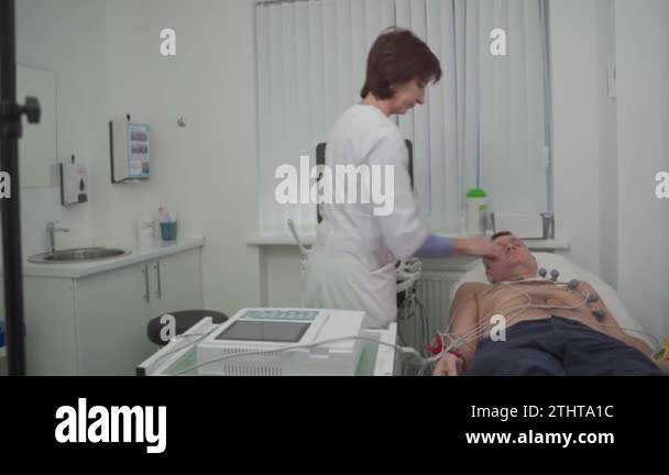 Medical equipment for electrocardiogram. Doctors doing ECG test on male ...