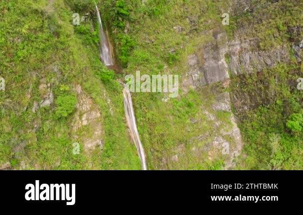 Cliff with a waterfall in the jungle. Cascade Waterfall on Luzon Island ...