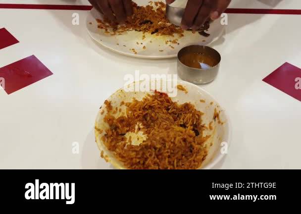Man eating Indian popular food chicken biriyani served with curd and ...