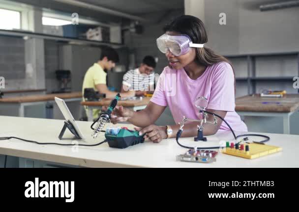 African American teenage female Student learning to solder electronics ...