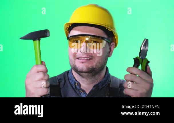Professional male builder on green screen. he holds tools in his hands ...