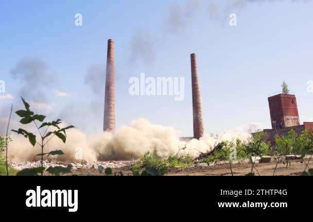 Demolition of old industrial brick pipe at the factory. Destruction and ...