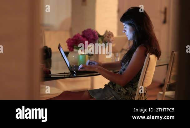 Candid woman in front of laptop at night working. Real life ...