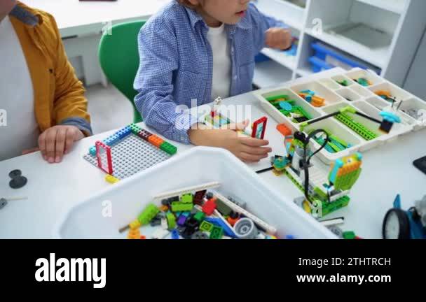Robotics programming class. Children construct and code Robot. STEM education using constructor ...