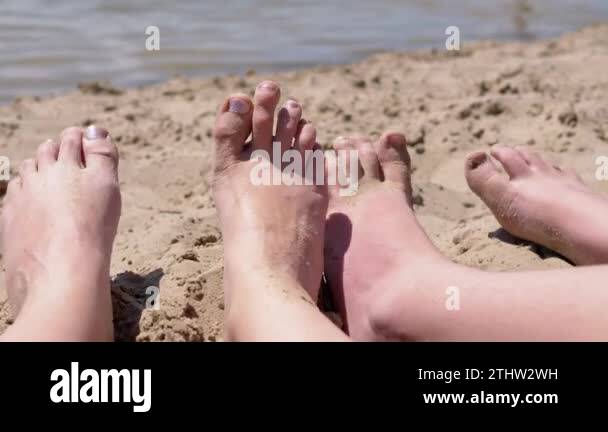 Bare Feet of Mother and Child in the Sand Lies on a Sandy Beach near ...