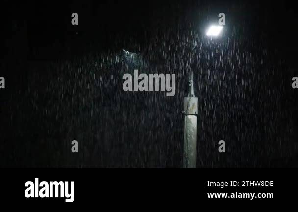 Double led panel lamppost under heavy rain at night. Midsize view of ...