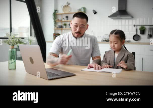 Asian Family Doing Homework Together At Home. Father helping daughter ...