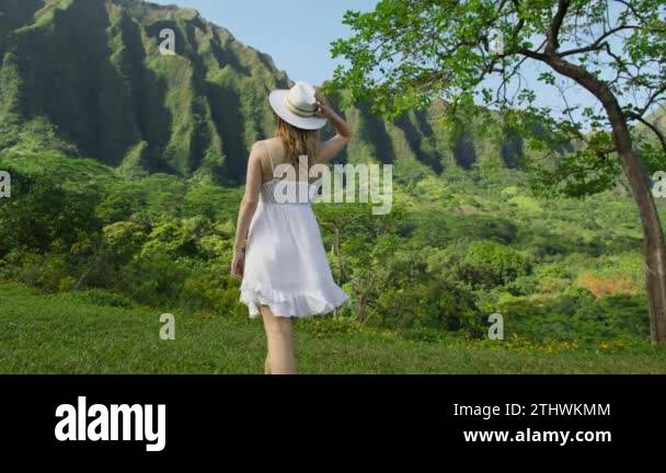 Young woman traveler rising hands at green jungle mountain background ...