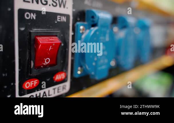 Close-up red button on the background of the blue power sockets of the ...
