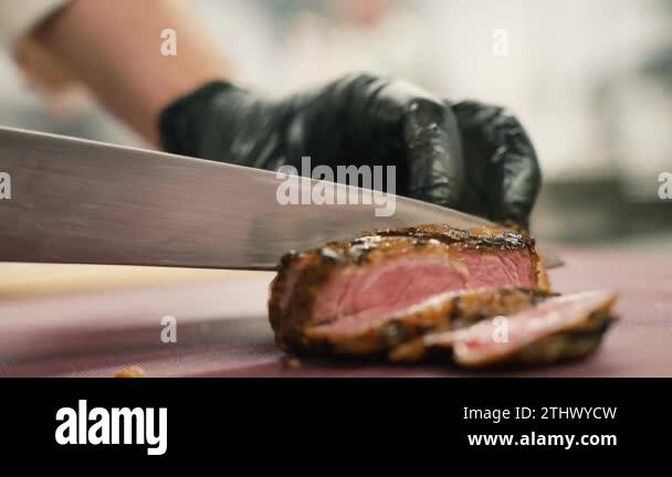 Process of cutting the steak with a large kitchen knife on a cutting ...
