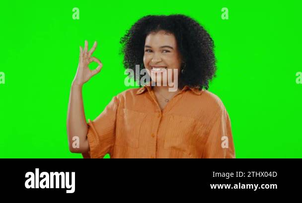 Ok, wink and smile with woman on green screen for happy, feedback and ...