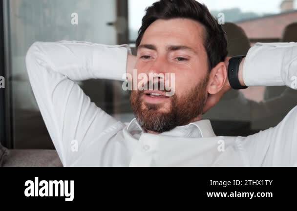 Successful satisfied young male company director relaxing at workplace ...