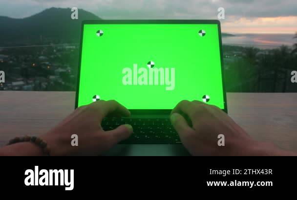 Male freelancer typing text on computer with green screen while sitting ...