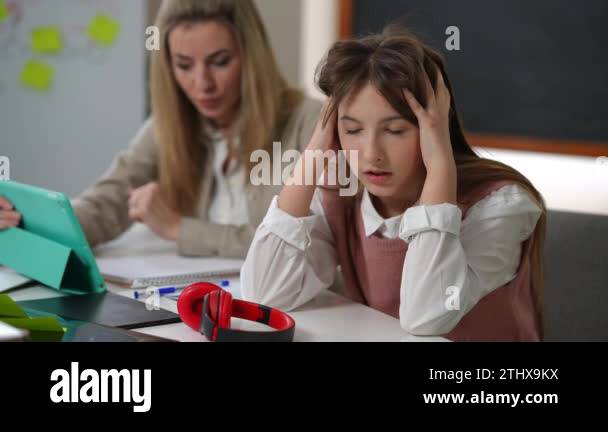 Exhausted overburdened teen schoolgirl looking at camera sighing as ...