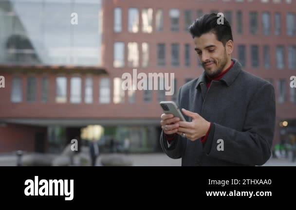 Multiracial Handsome Man Standing Outside Using His Smartphone and Swiping. Male Manager ...