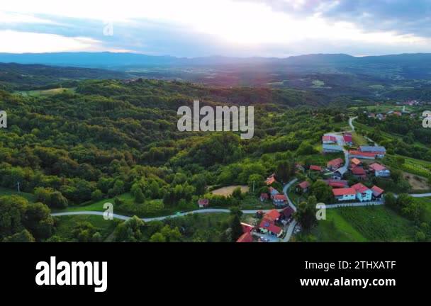 A small cozy village with cute houses and paved roads in a valley with ...