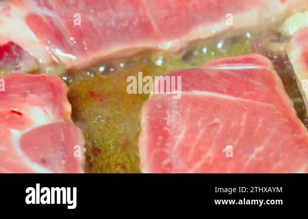 Searing beef bottom round roasted meat in cast iron skillet in boiling ...