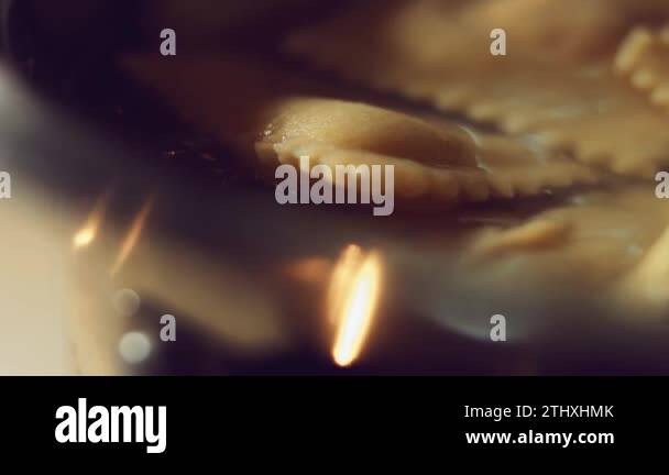 Close-up of cooking ravioli by placing them in a pan with boiling water ...