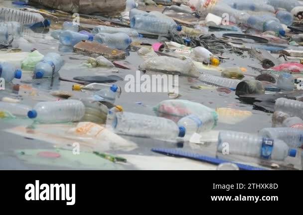 Environmental pollution. Plastic bottles, bags, trash in river, lake. Rubbish and pollution ...