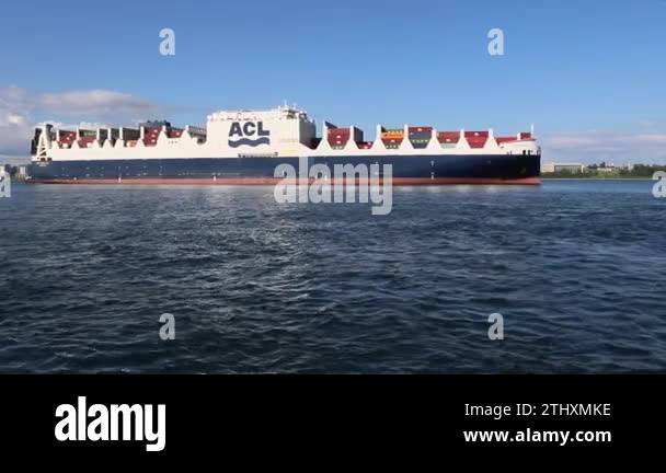 A cargo ship loaded with containers leaves the port. The system of ...