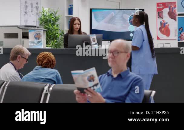Diverse medical staff working on appointments at reception desk in ...