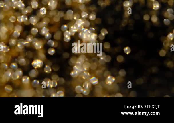 Golden glitter background in slow motion. Beautiful transition with real gold particles. flying ...