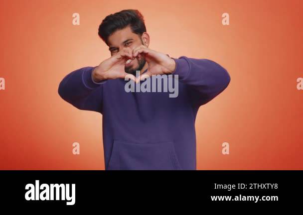 Man in love. Smiling bearded indian man 25 years old makes heart ...