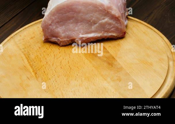 Butcher preparing meat and knives. The cook lays out a selected piece ...