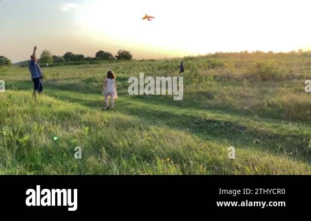 Happy grandfather spending time with kids outdoors at sunset. Family ...