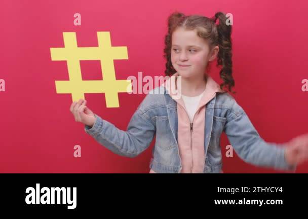 Portrait of happy smiling little girl kid holding big yellow hashtag ...