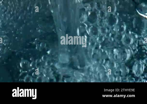 Bubbling beverage filling glass closeup. Top view diverse air bubbles ...