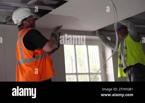 Hard male work on construction site. Two professional workers in ...