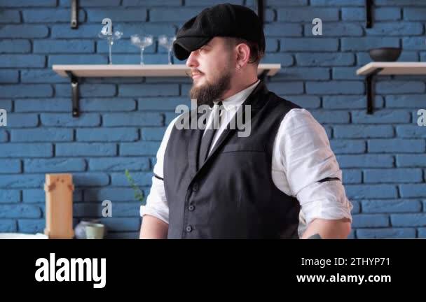 Handsome, authentic, cheerful, smiling bartender folds hands and poses ...