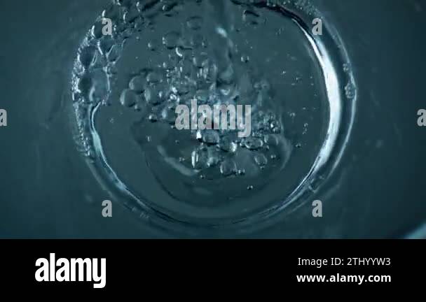 Top view water pouring transparent cup closeup. Diverse air bubbles ...