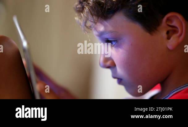 Digital native child addicted to tablet device. Young boy absorbed by ...