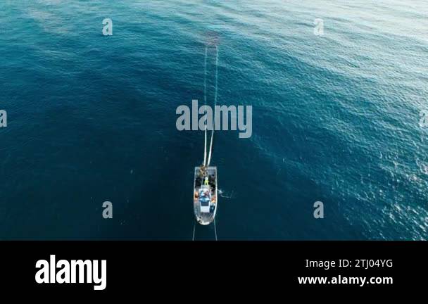 White small fisherman trawler with crew on board. People work together ...