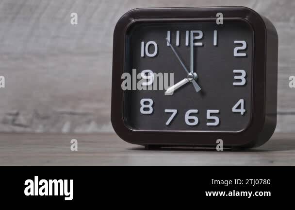 The pointer clock on wooden table shows time 8 oclock. Arrow brown ...