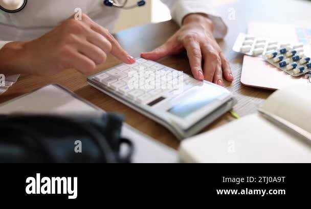 Doctor with stethoscope calculate costs and revenues for paying for ...