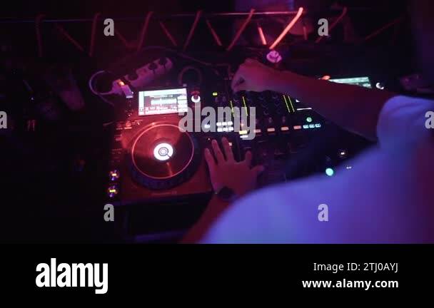 Faceless DJ mixing music at the decks of the nightclub. Detail of hands ...