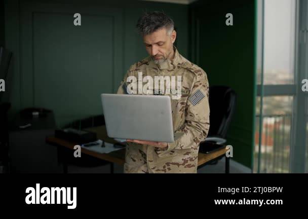 Soldier working with laptop in home. Everyday life of a military man in ...