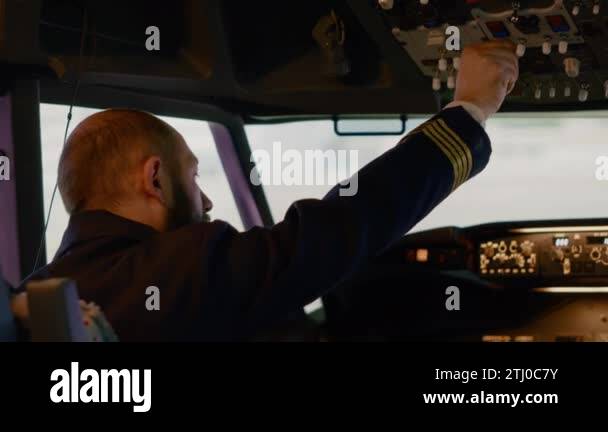 Airplane captain starting engine with power buttons on dashboard to fly ...